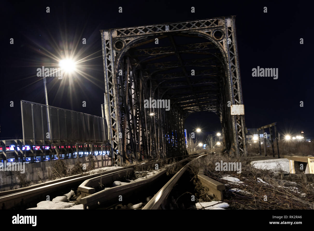 A metalic railroad bridge at night Stock Photo - Alamy