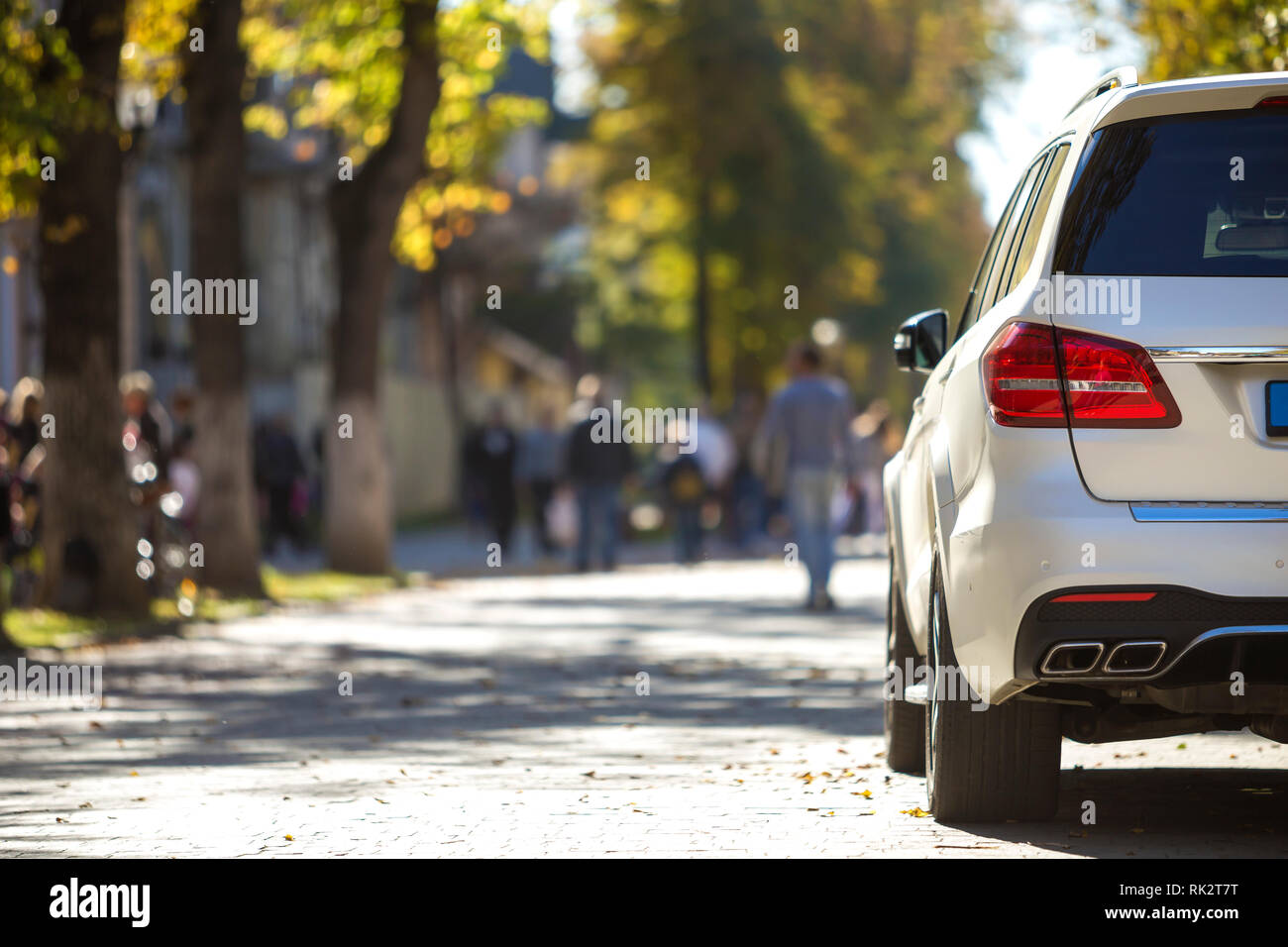 Back view of white car parked on city pedestrian zone on background of ...