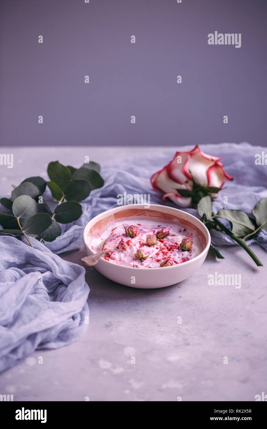 Bowl of yogurt with raspberry powder and dried rose buds Stock Photo ...