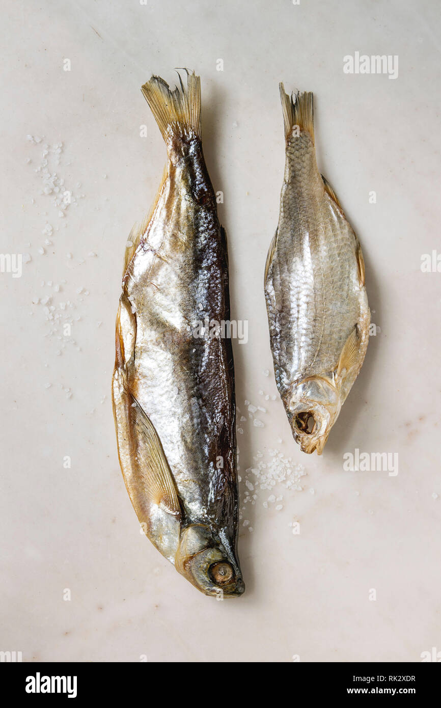 Dried fish or stockfish over white marble background. Flat lay, space ...