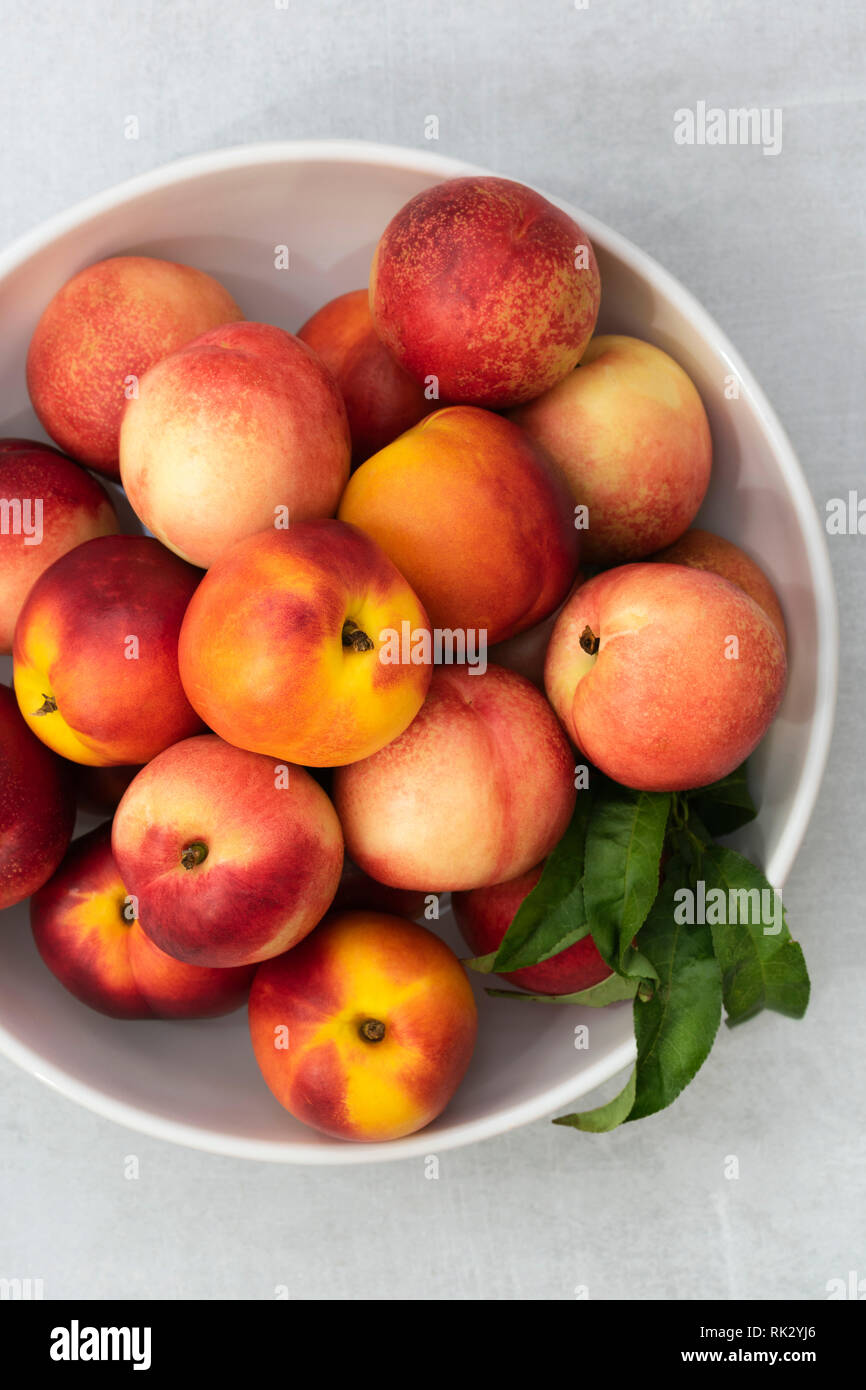 Whole red and yellow nectarines in a bowl Stock Photo - Alamy