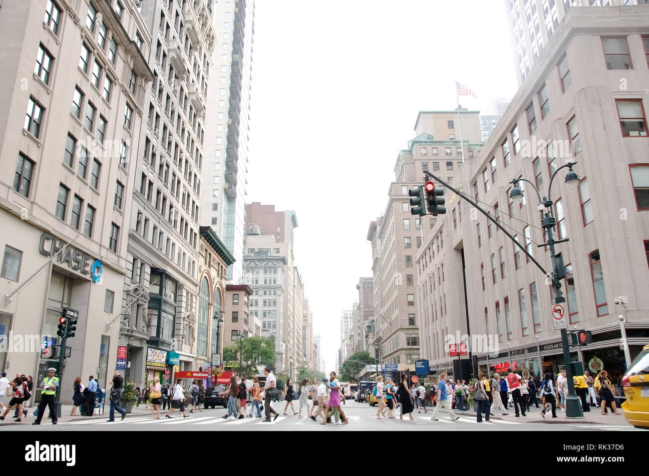 People crossing the pedestrian lane on one of the cross streets of 5th ...