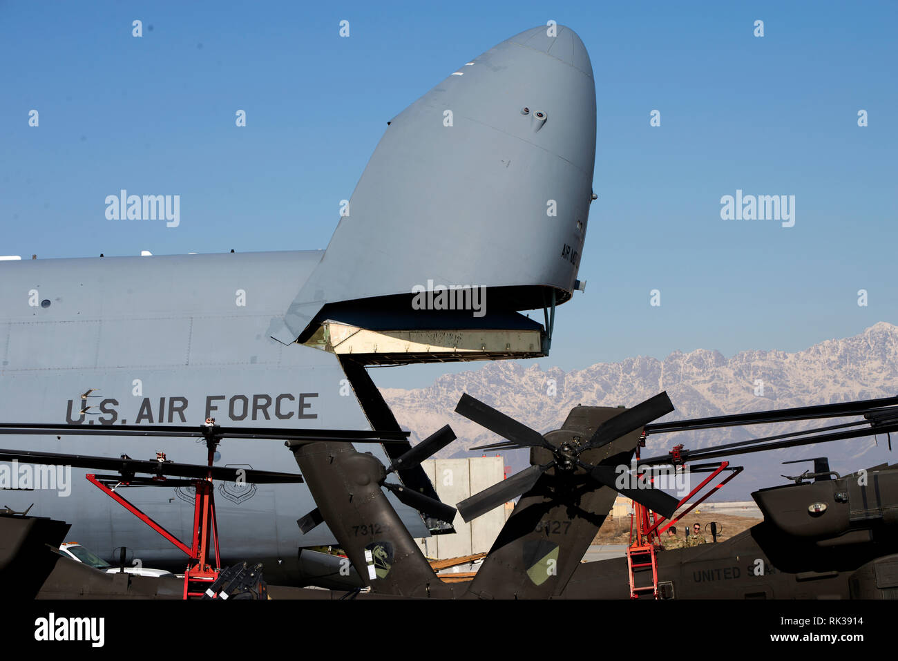 Airmen, Soldiers, and personnel prepare to load Apache Helicopters into ...