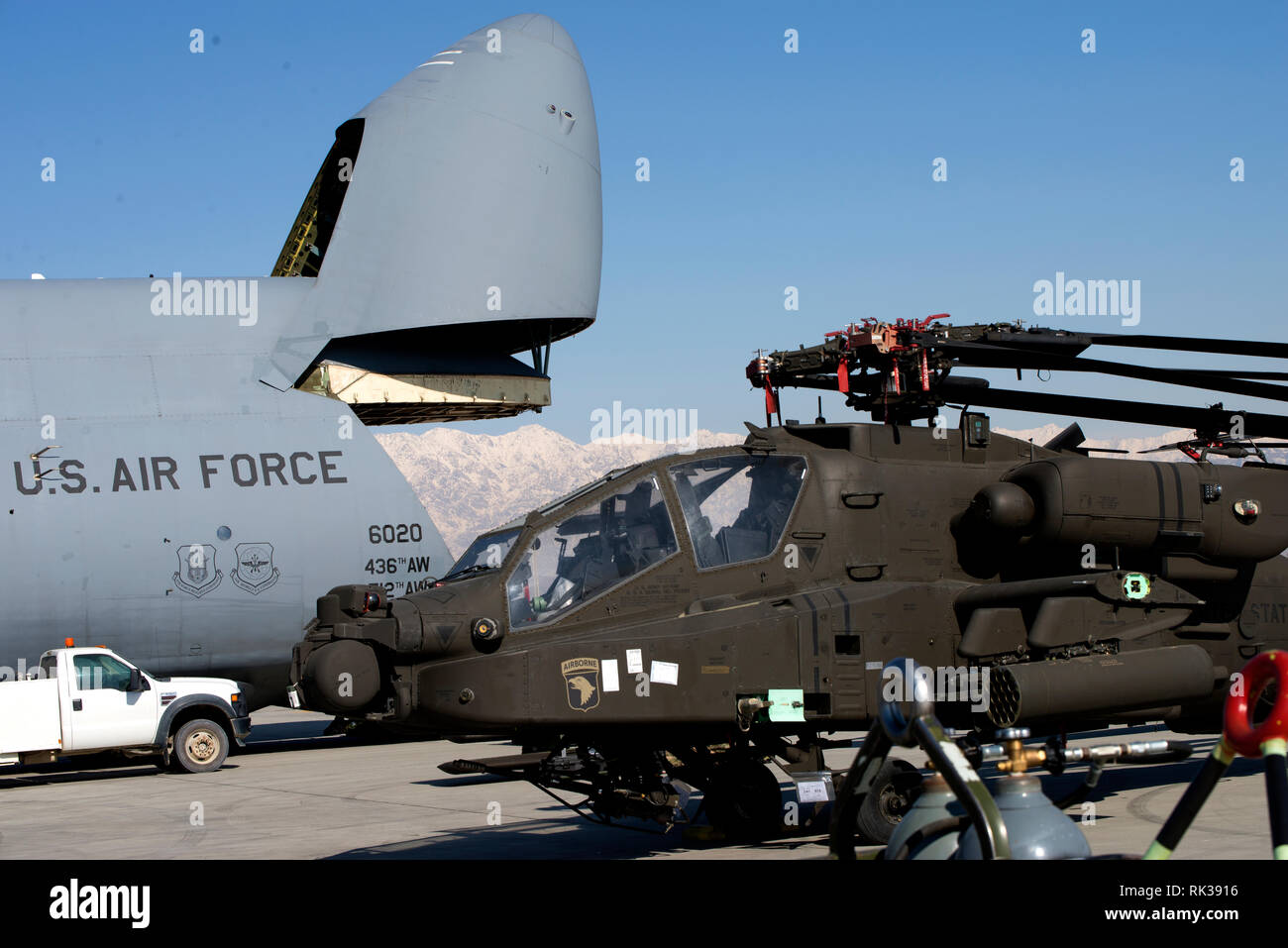 Airmen, Soldiers, and personnel prepare to load Apache Helicopters into ...