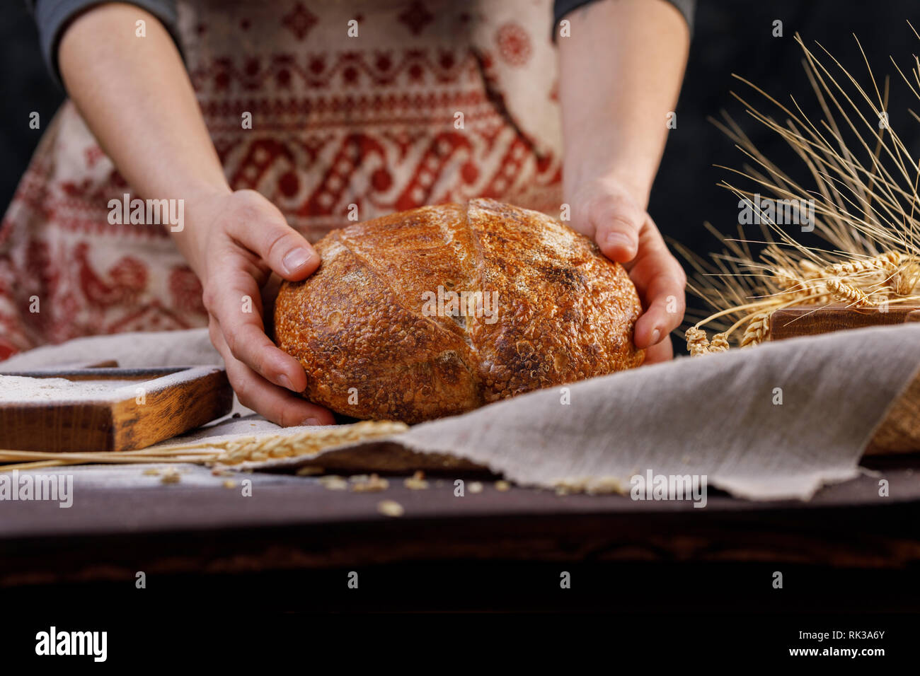 Hands holding round artisan bread. The concept of healthy food and ...