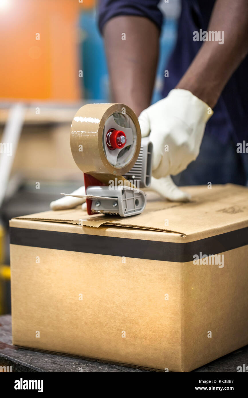 Box being taped shut in packaging plant Stock Photo - Alamy