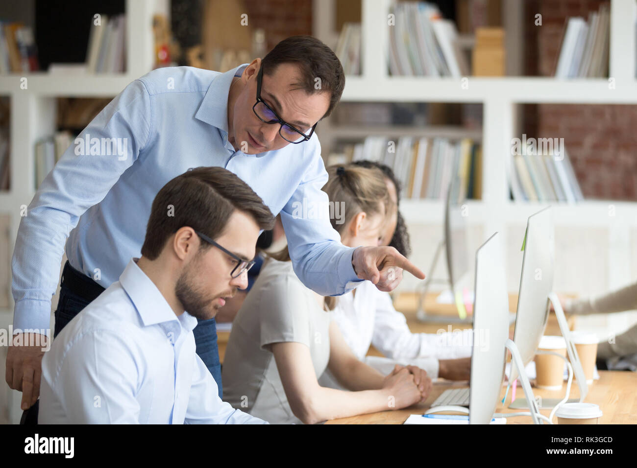 Angry boss criticizing scolding sad male employee for computer mistake ...