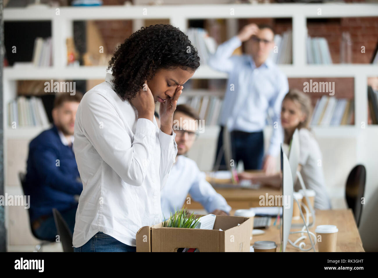 Sad african female employee packing belongings in box got fired Stock ...