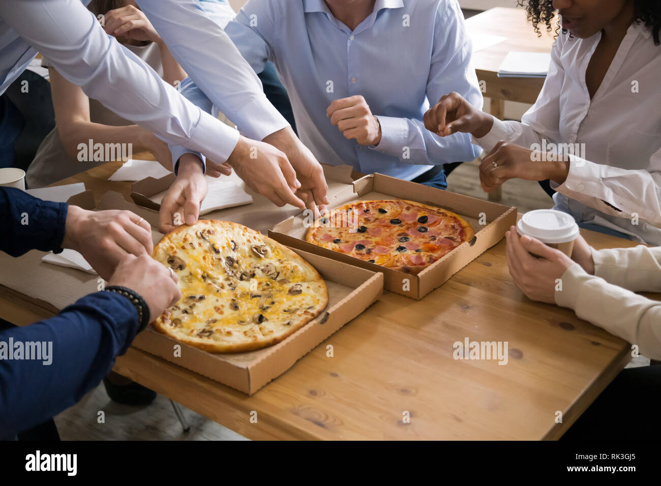 Diverse staff people sharing pizza hands taking slices from box Stock ...