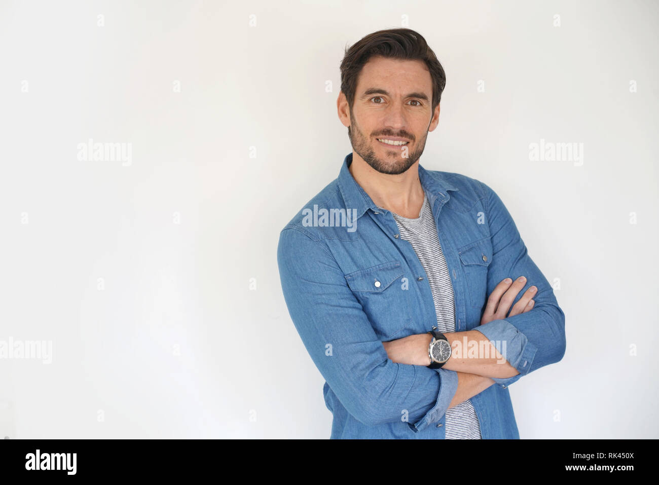 Very handsome casual man smiling and standing on white background Stock ...