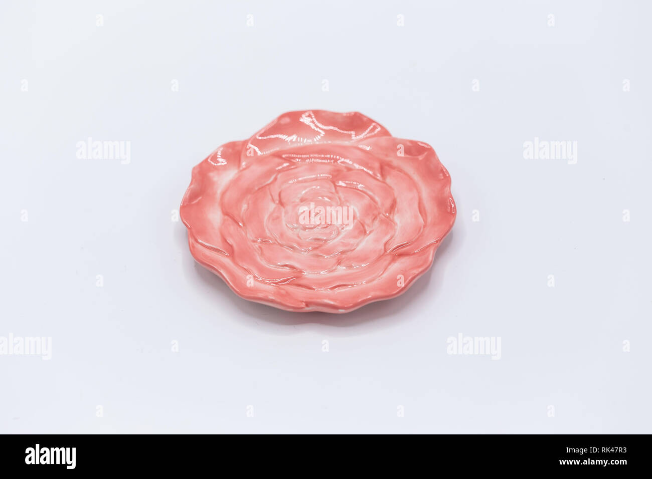 a small pink decorative plate shaped like a small flower Stock Photo ...