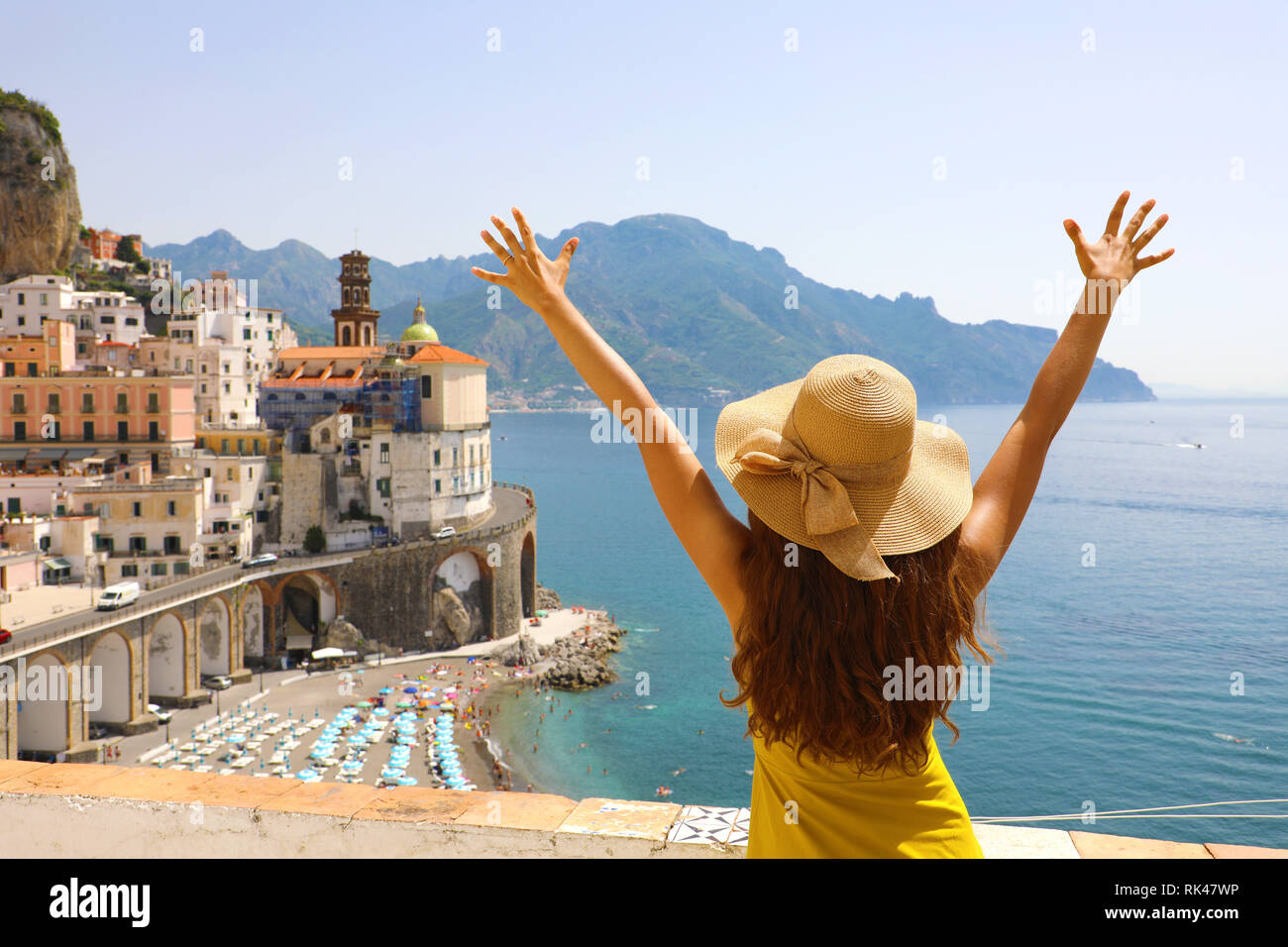 Summer holiday in Italy. Back view of young woman with straw hat and ...