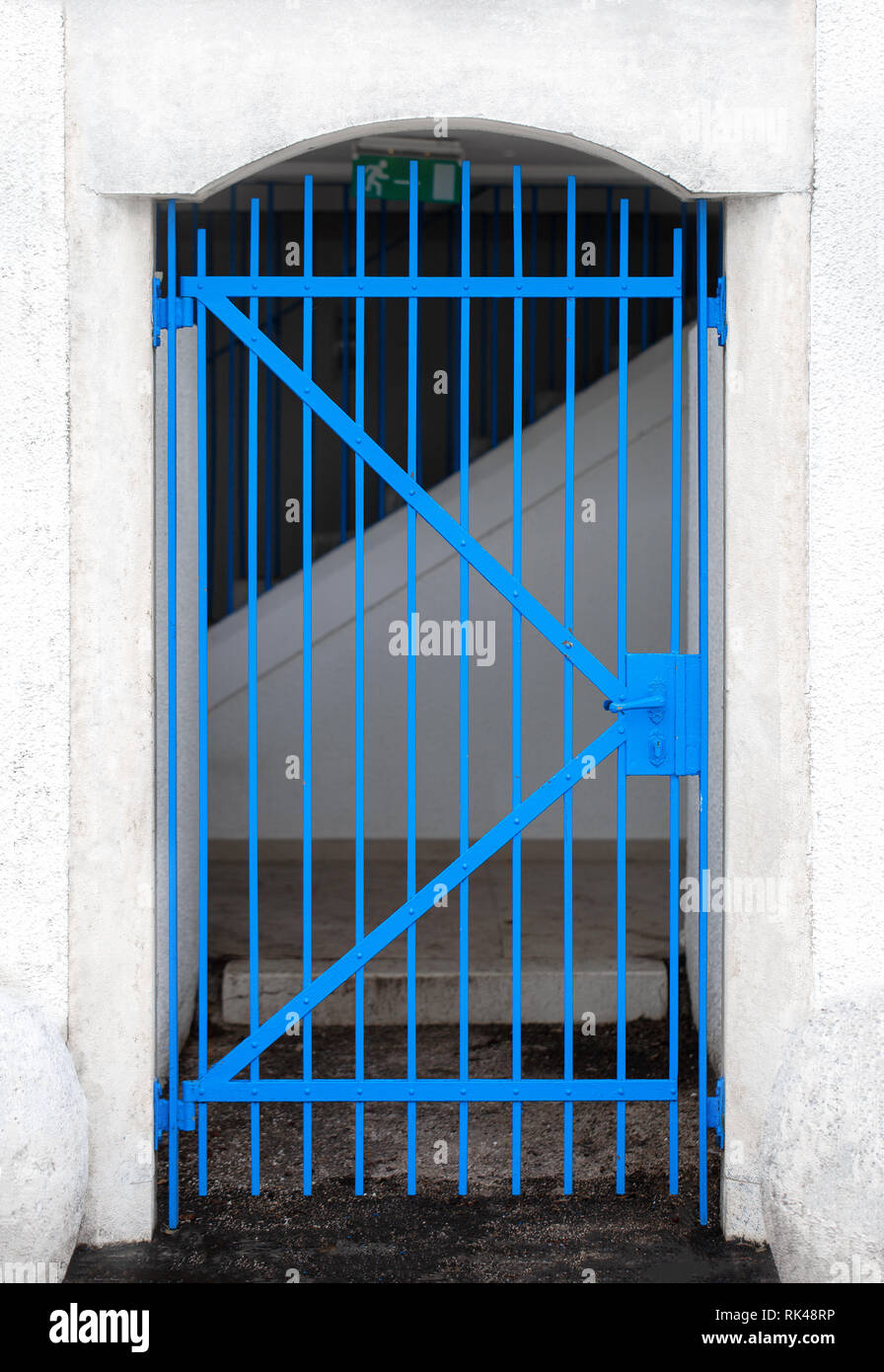 Iron blue lattice gate in a white wall Stock Photo - Alamy