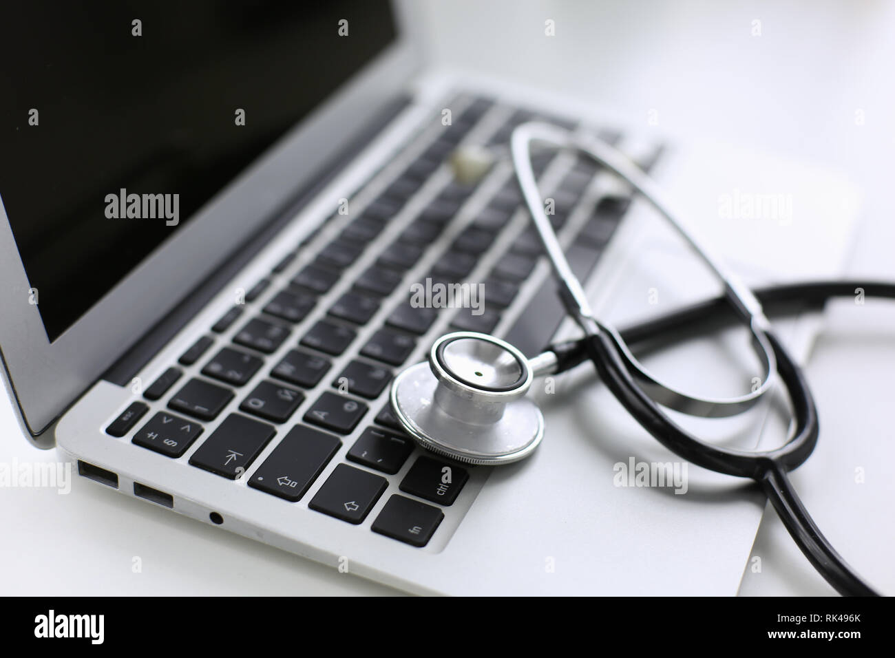 Stethoscope lying on a laptop keyboard in a concept of online medicine ...