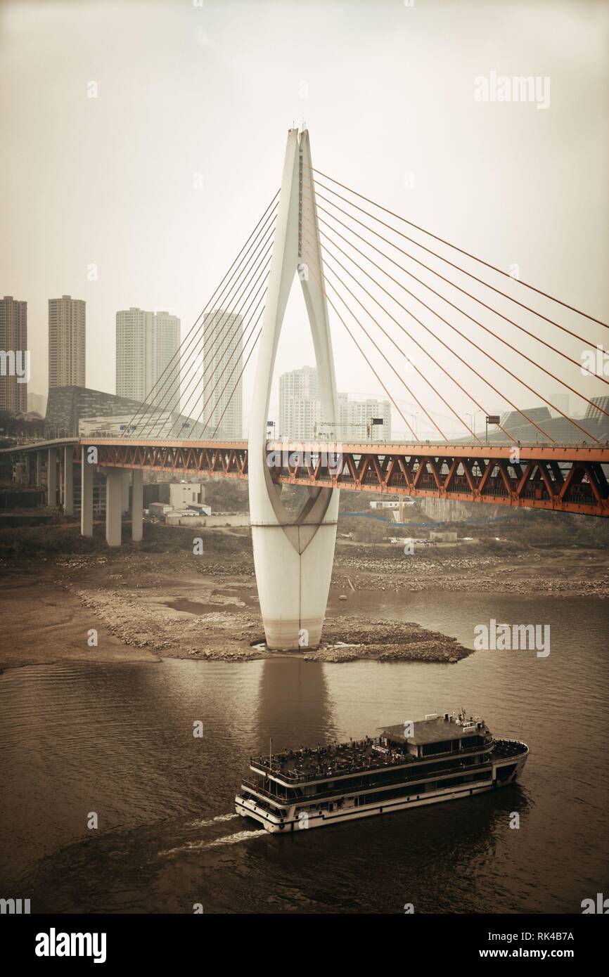 Boat pass below bridge with city urban architecture in Chongqing, China ...