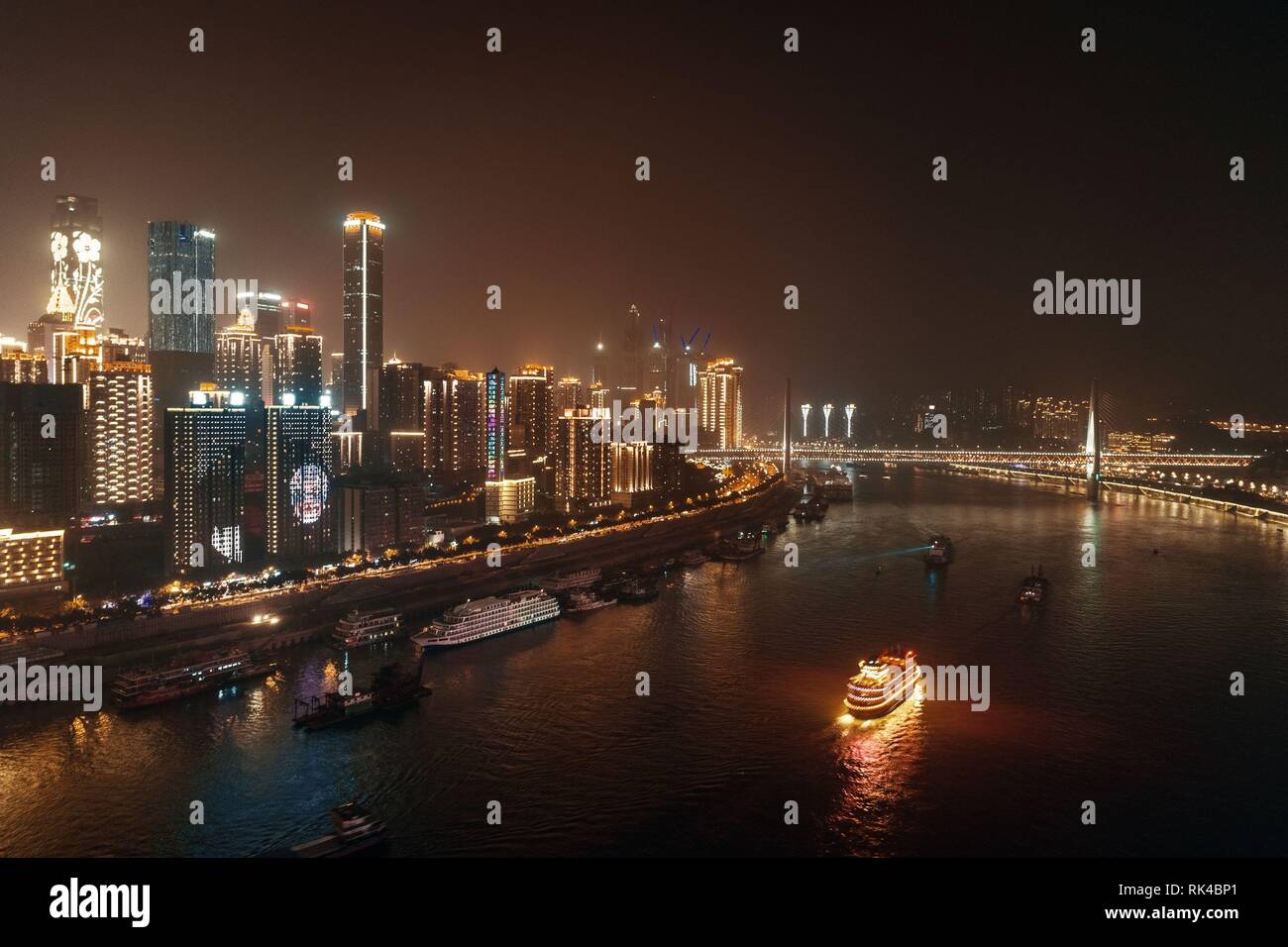 Aerial view of urban buildings boat and city skyline at night in ...