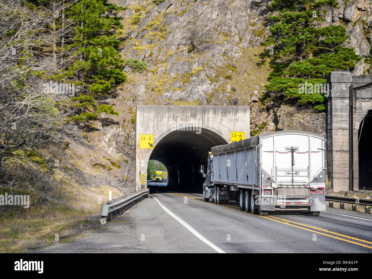 Two big rig commercial long haul semi trucks transporting cargo in semi ...