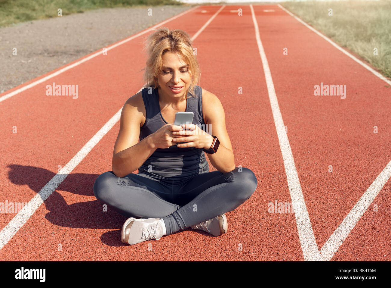 Young woman athlete on stadium sporty lifestyle sitting on track ...