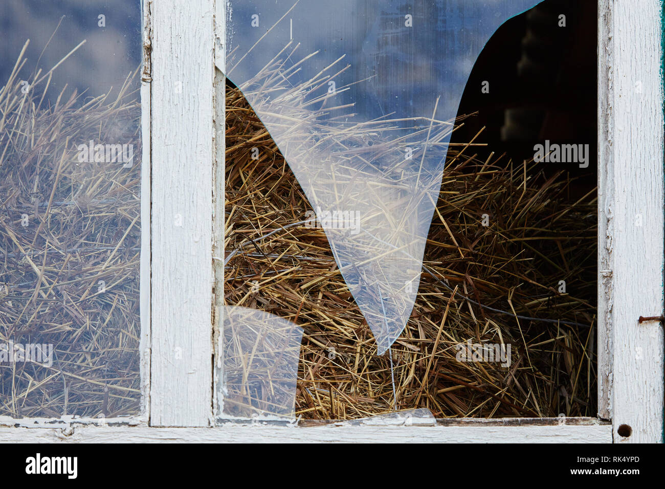 Broken glass in an old window of the hayloft. old village barn with old ...