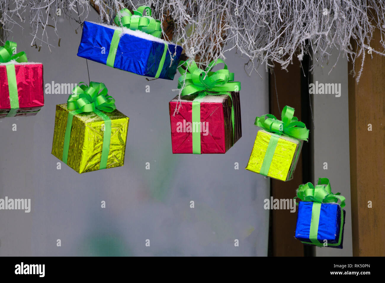 Red gift boxes hanging on a ribbon Old brown paper background Stock ...