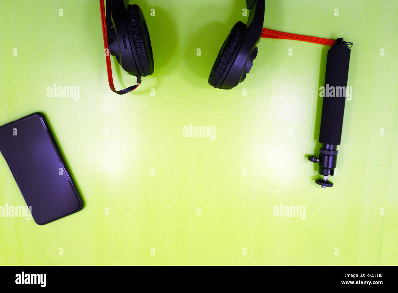 A white smartphone charging with a yellow powerbank set on light blue ...