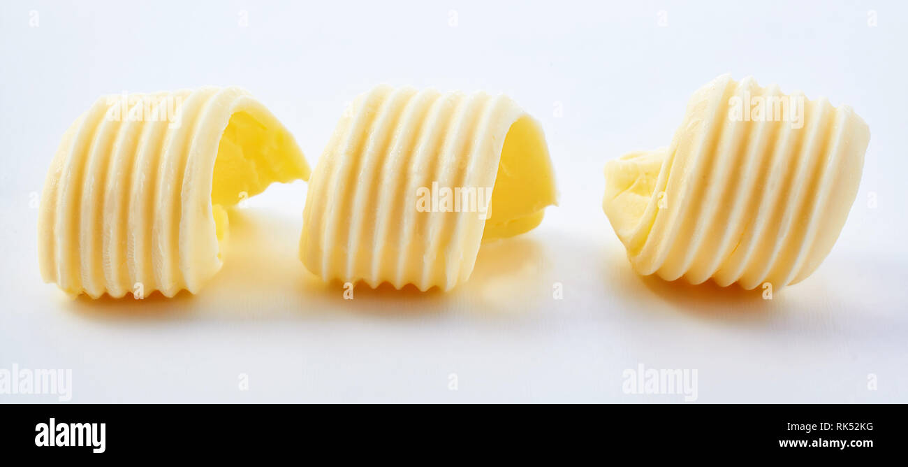 Three butter curls viewed in close-up on white surface background Stock ...