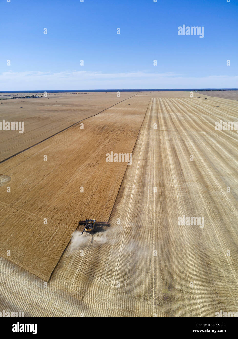 Aerial of barley harvesting with a modern wide comb combine harvester ...