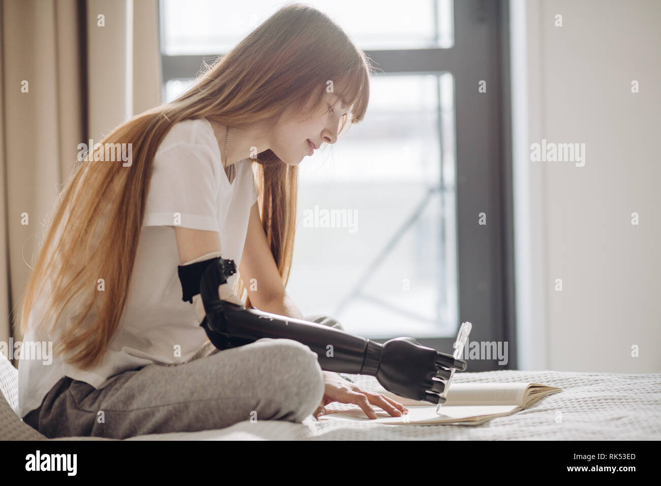 disabled female student writing a report. close up photo. copy space ...