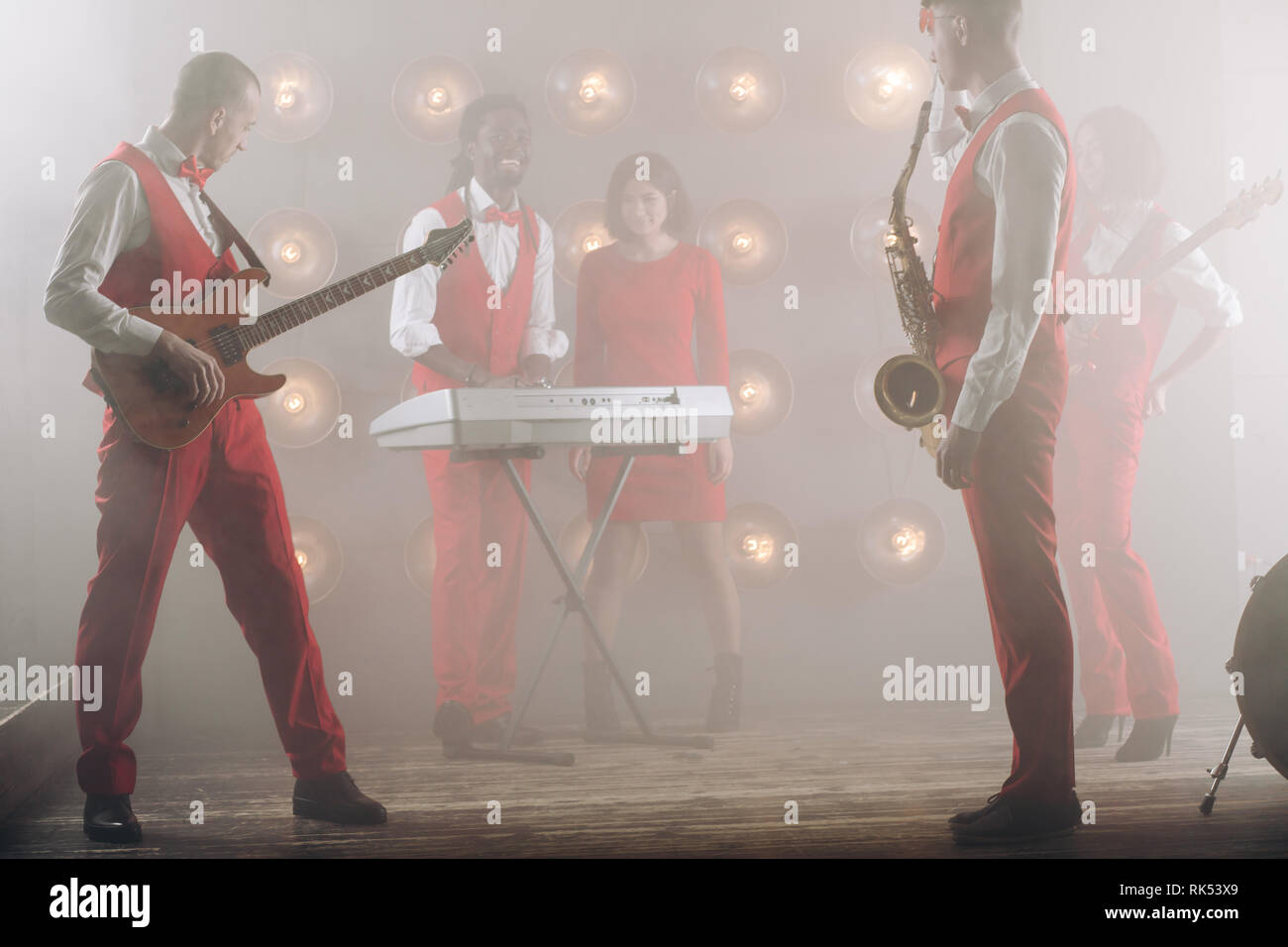 mixed race band practising their performance on the stage. close up ...