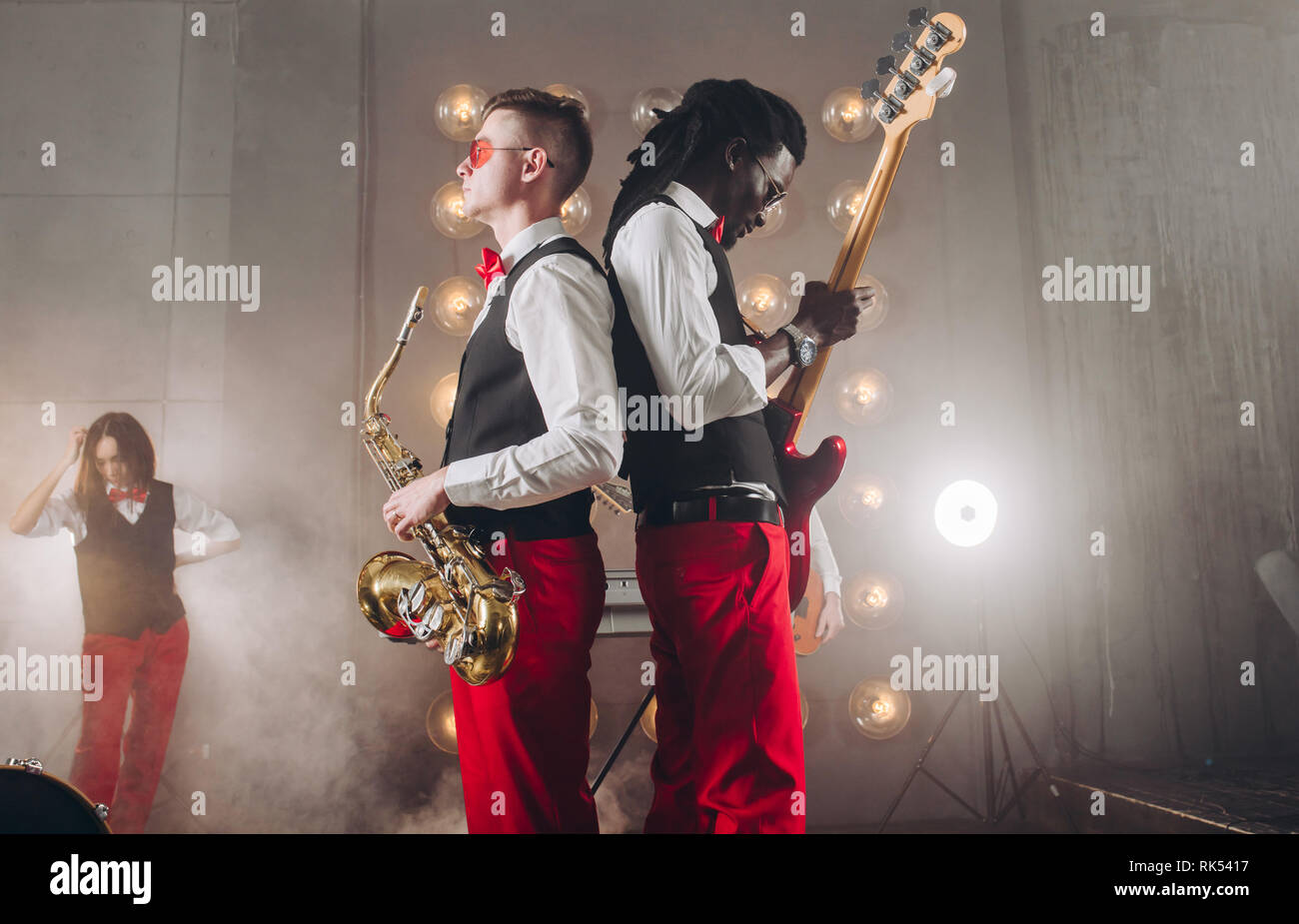 two talented men standing back to back and rehearsing the music at the ...