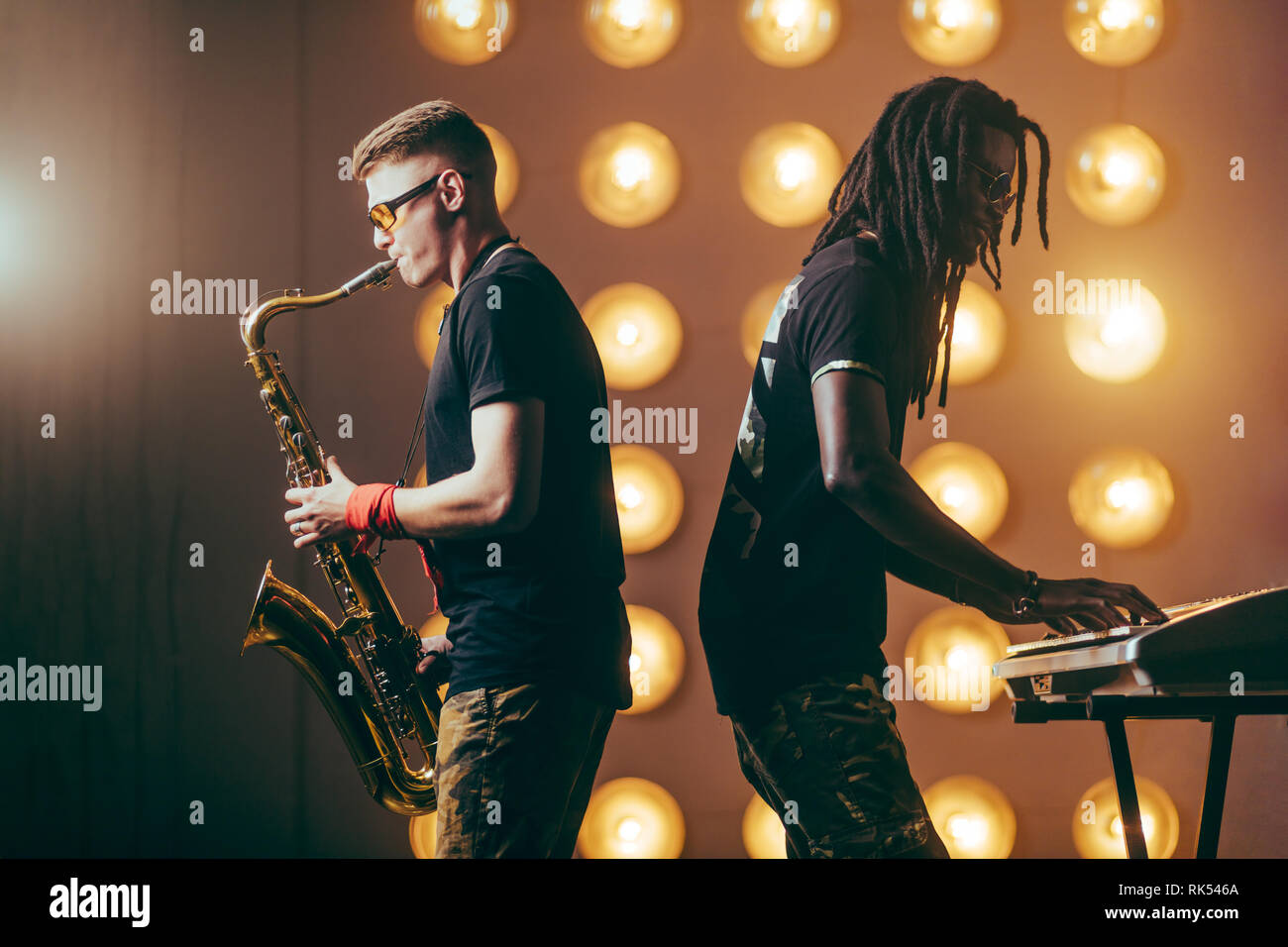 two musicians performing on the stage. close up side view photo ...