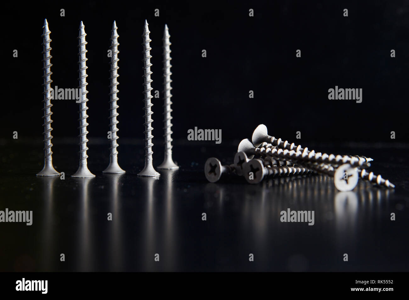 many black screws on a black background Stock Photo - Alamy