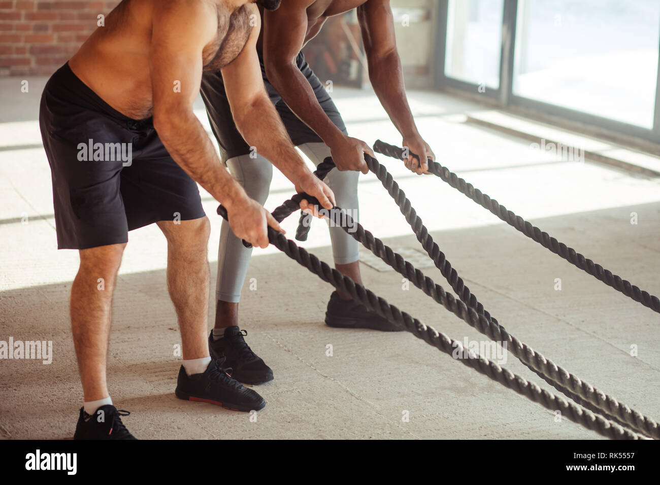 Two multiethnic atletic friends test the strength of an invisible enemy ...