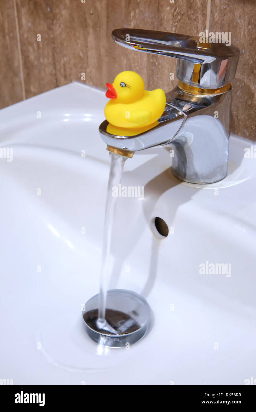 Rubber duck as a decoration of the bathroom interior near the tap and ...