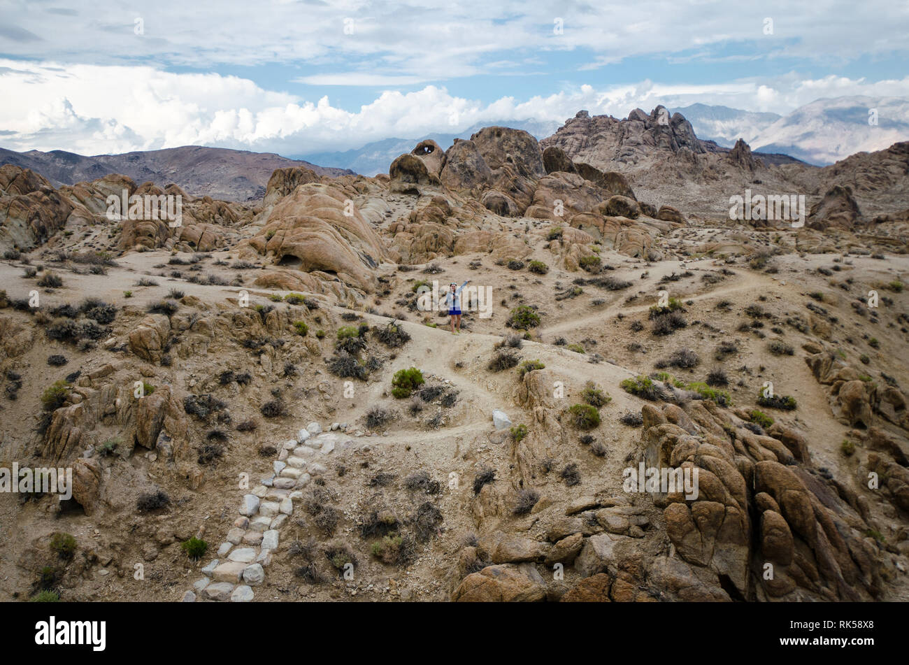 Woman hiker walks along a dirt trail through the Alabama Hills to the ...