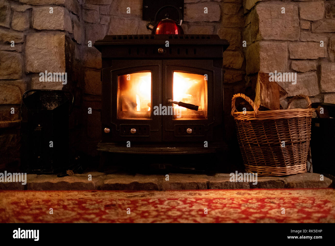 Wood burning fire in cosy cottage Stock Photo - Alamy