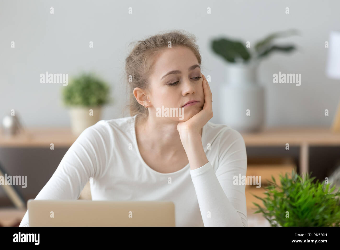 Bored unmotivated millennial woman thinking of dull work on laptop ...