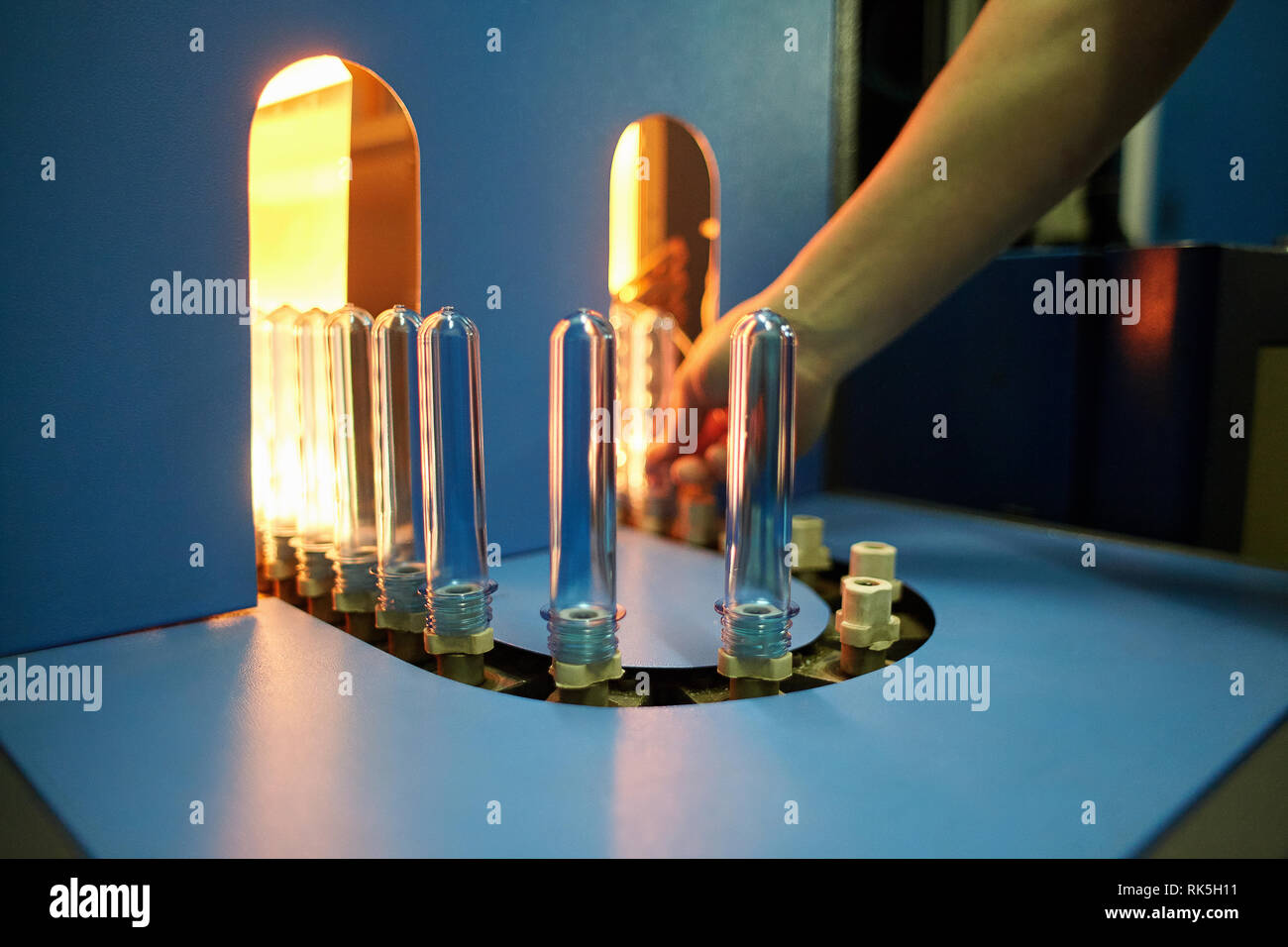 Pet bottle with natural water manufacturing. Soft focus. Worker's hands ...