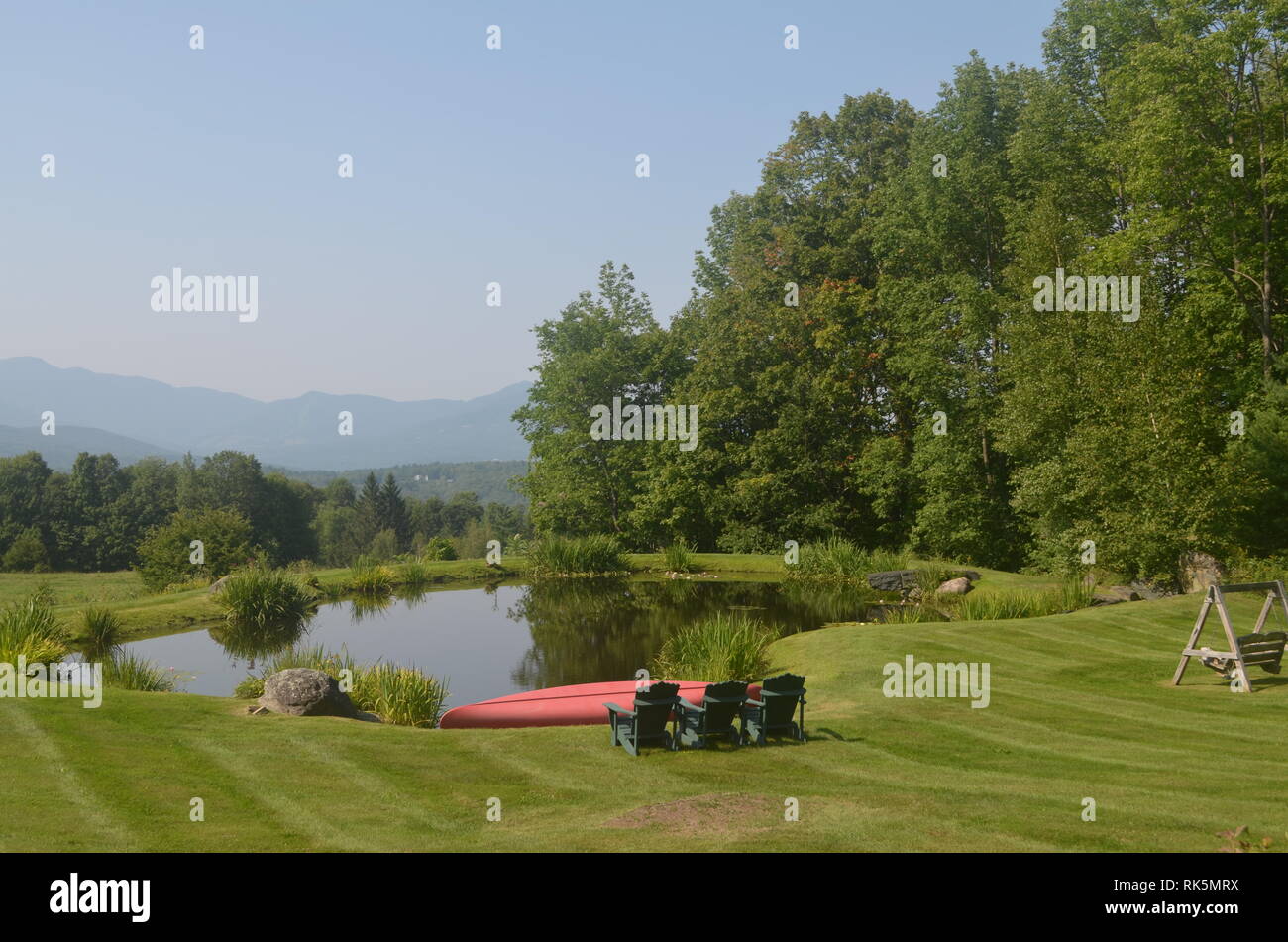 Swimming pond and red canoe Stock Photo - Alamy