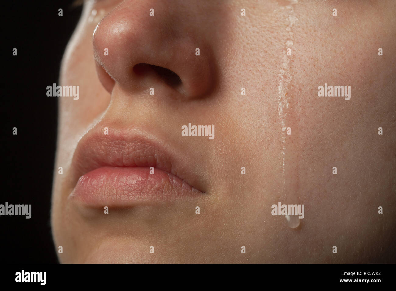 sad woman cries, shot a close up of female cheek with a tear drop Stock ...