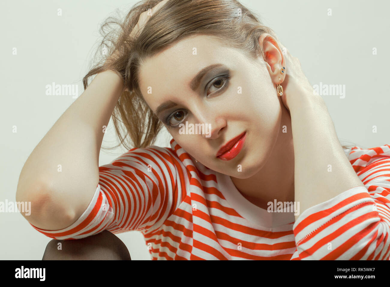 sly young woman smiling looking at camera on white background Stock ...