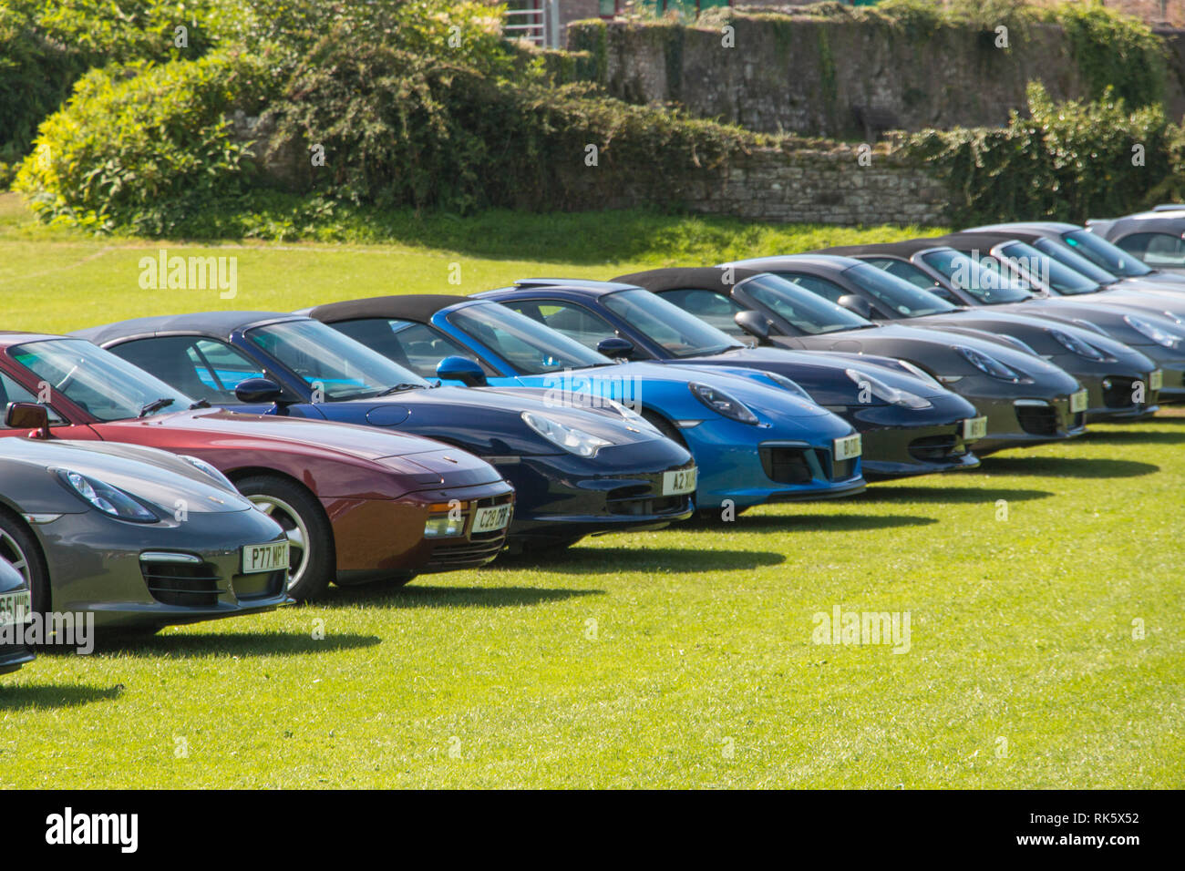 Porsche cars in line parked on grass Stock Photo - Alamy