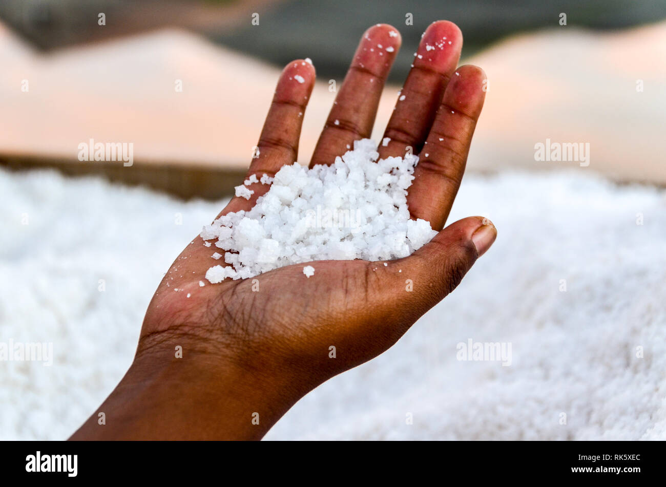 Open hand of a black female holding salt crystals from a wagon full of ...