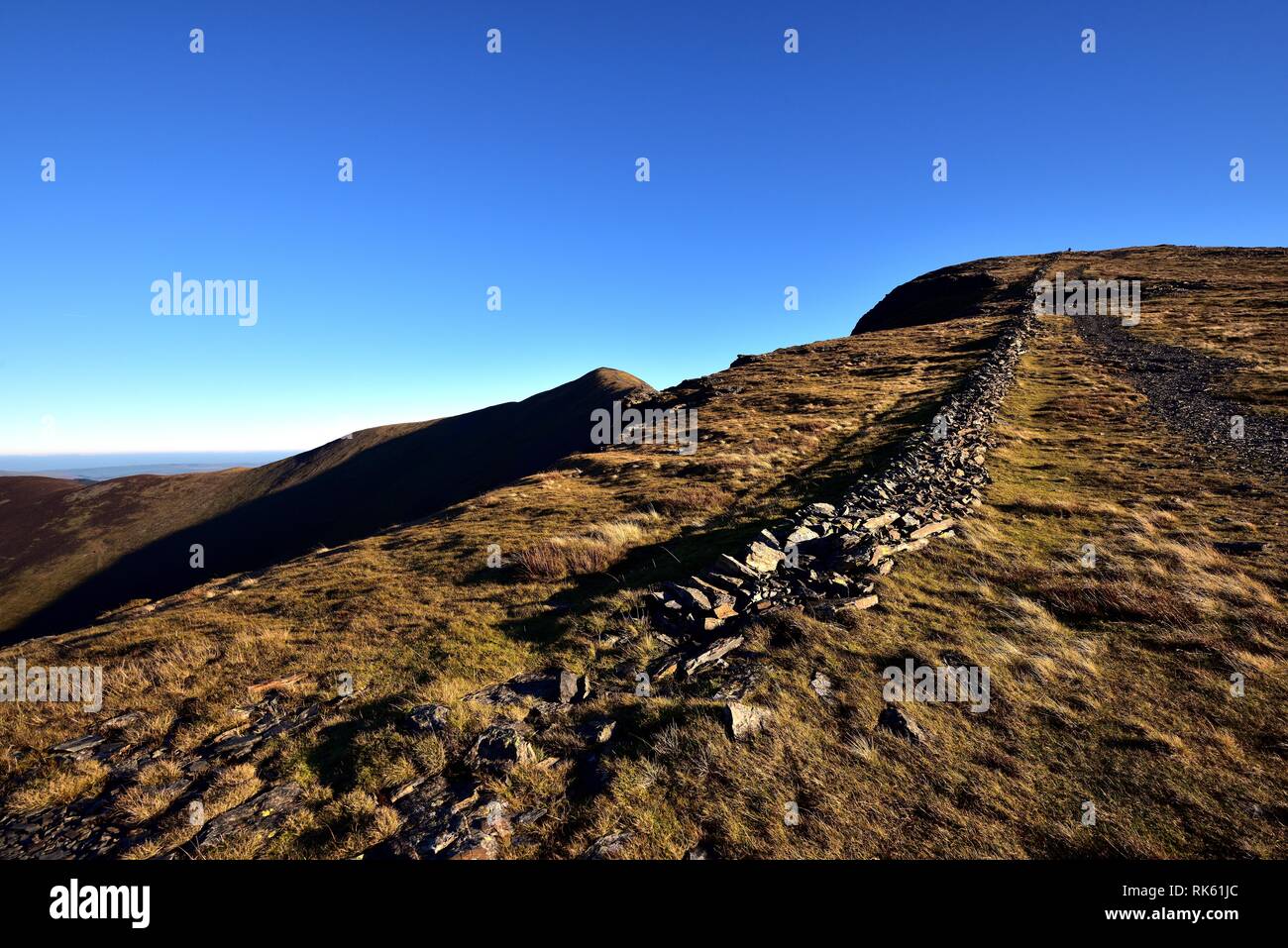Btumbled dry stone wall up the ridge line Stock Photo - Alamy