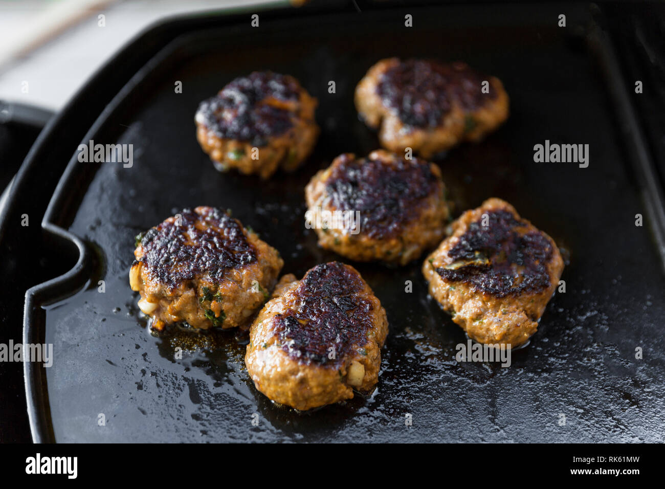 Small burger patties sizzling on barbecue hot plate Stock Photo - Alamy