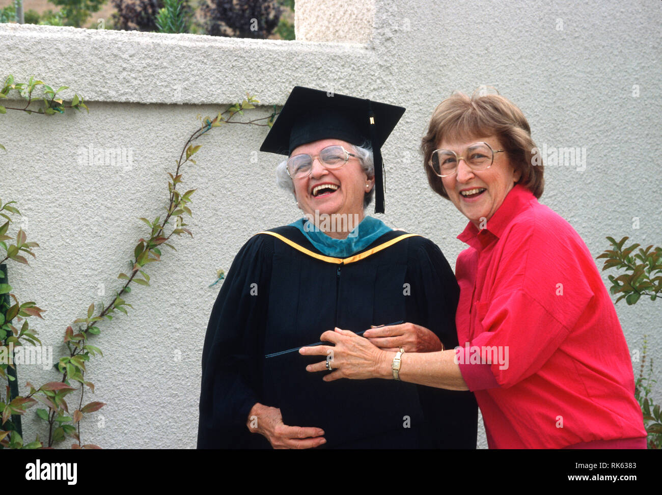 Senior Woman Graduating in Cap and Gown showing off Her Diploma to Good ...