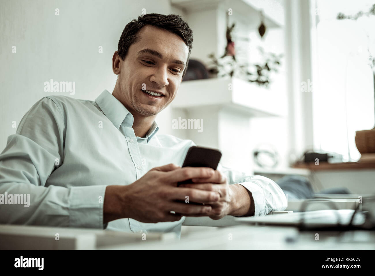 Pleased male person typing message to his partner Stock Photo - Alamy