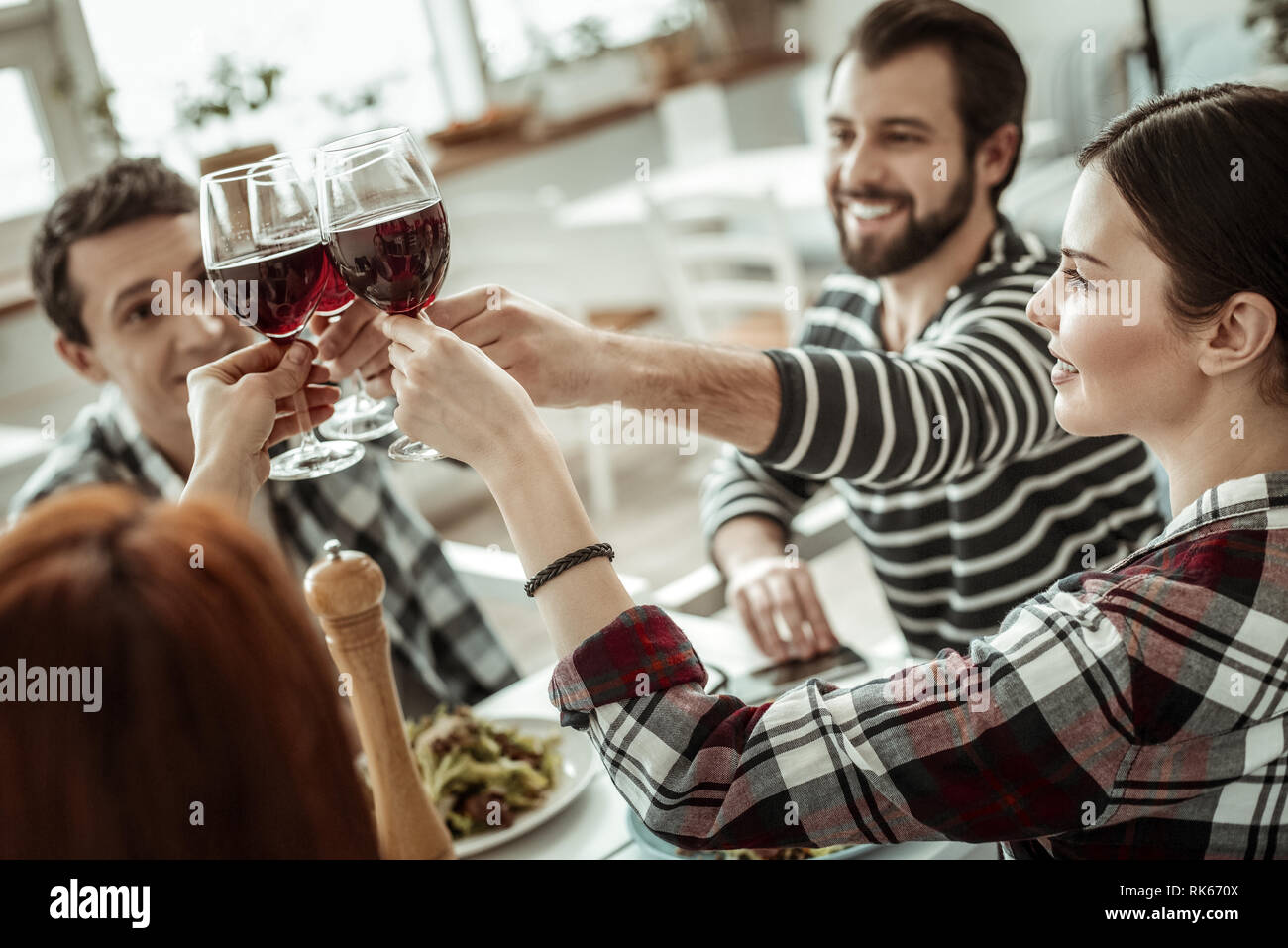 Joyful people sitting together around big table Stock Photo - Alamy