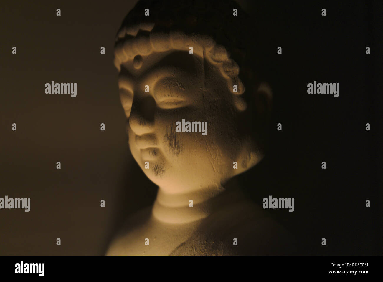 buddha holding a glass can with a candle in it. dark environment creepy ...