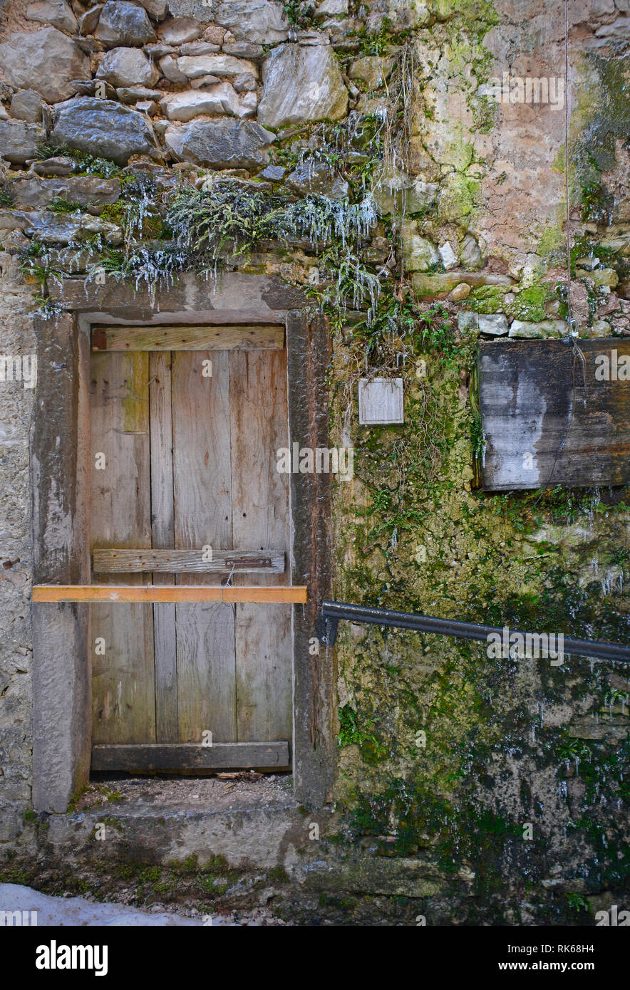 A door in an abandoned building in the hill village of Casso in winter ...